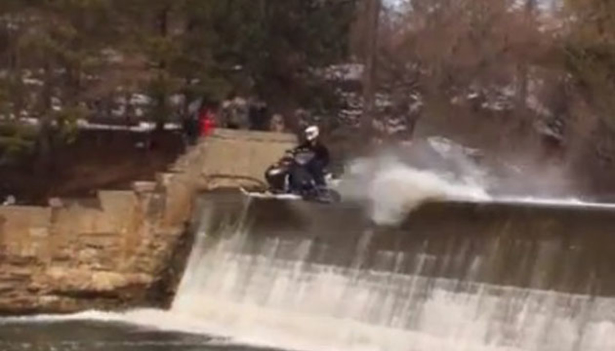 Snowmobile jumps over dam